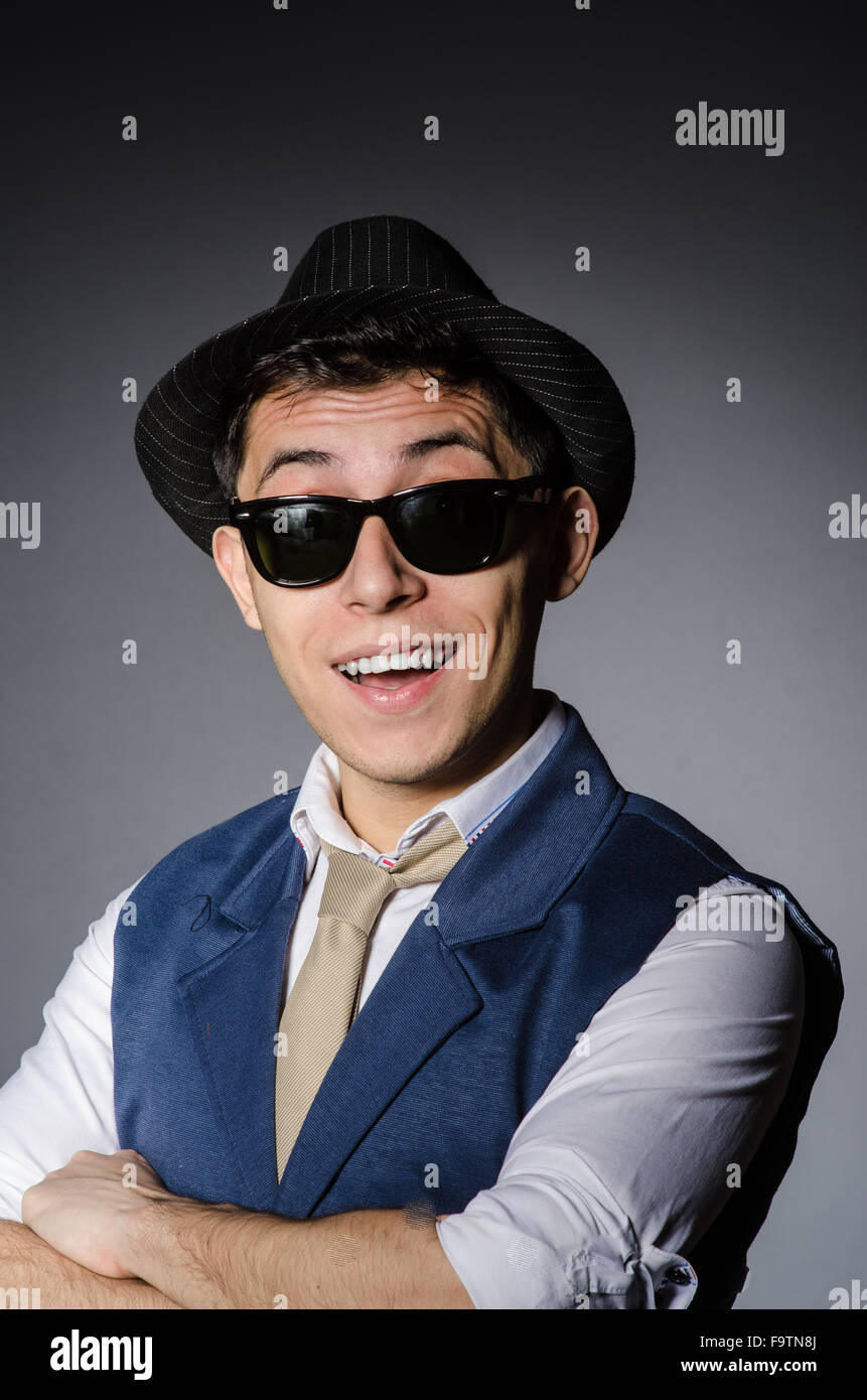Young man in blue vest and hat against gray Stock Photo - Alamy
