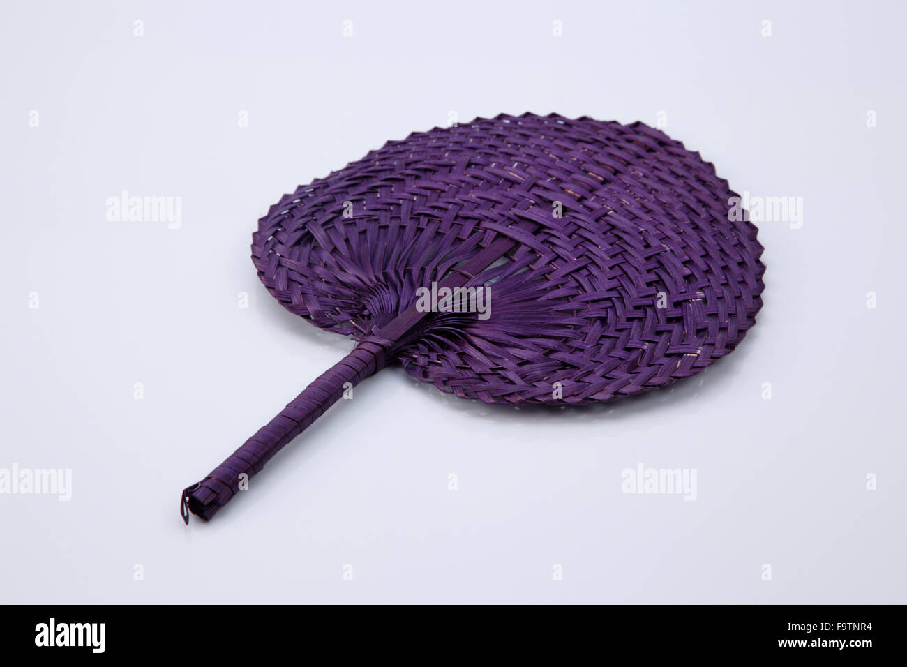 Purple color native fan made from palm leaves on white background Stock ...