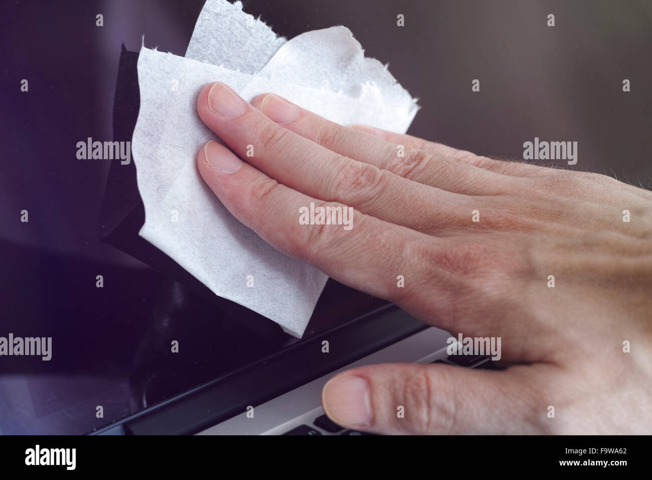 Man cleaning dusty laptop screen with wipe. Close up Stock Photo - Alamy