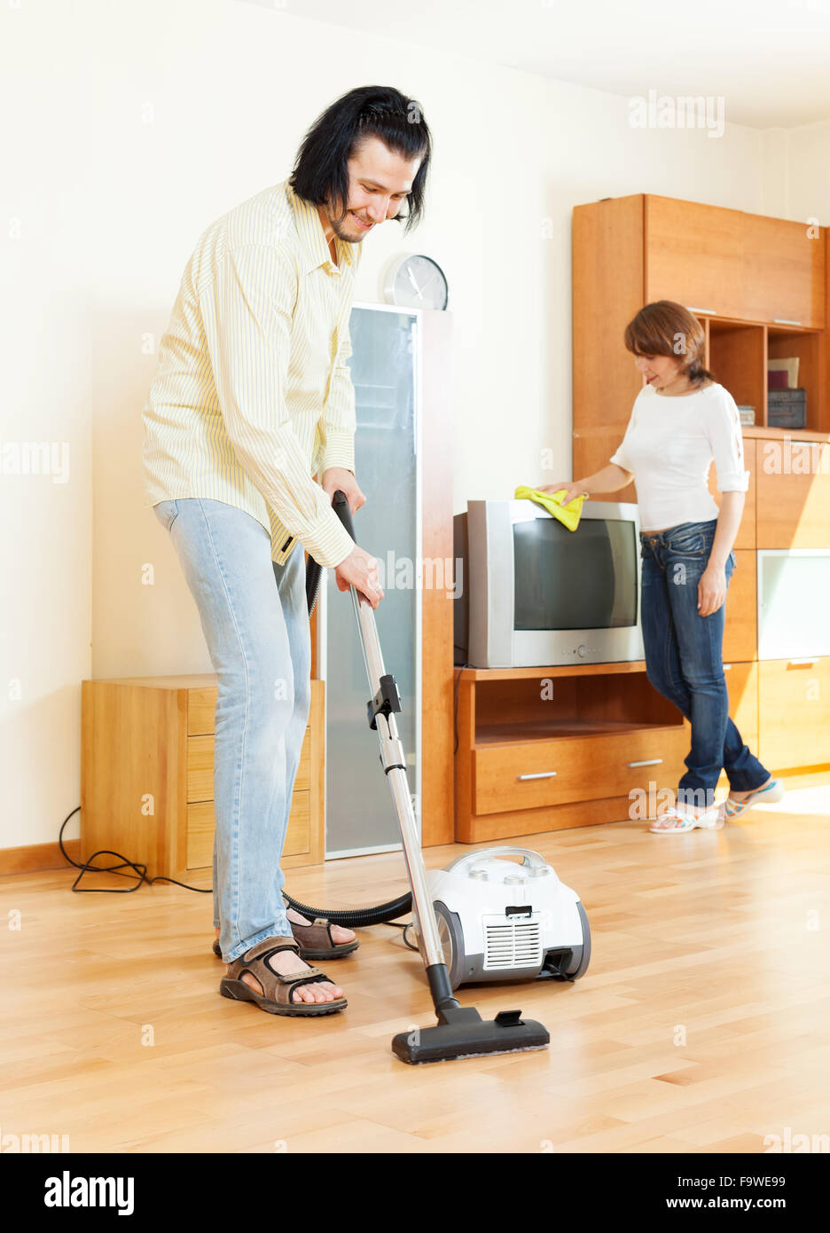 Happy middle-aged couple doing housework together Stock Photo - Alamy