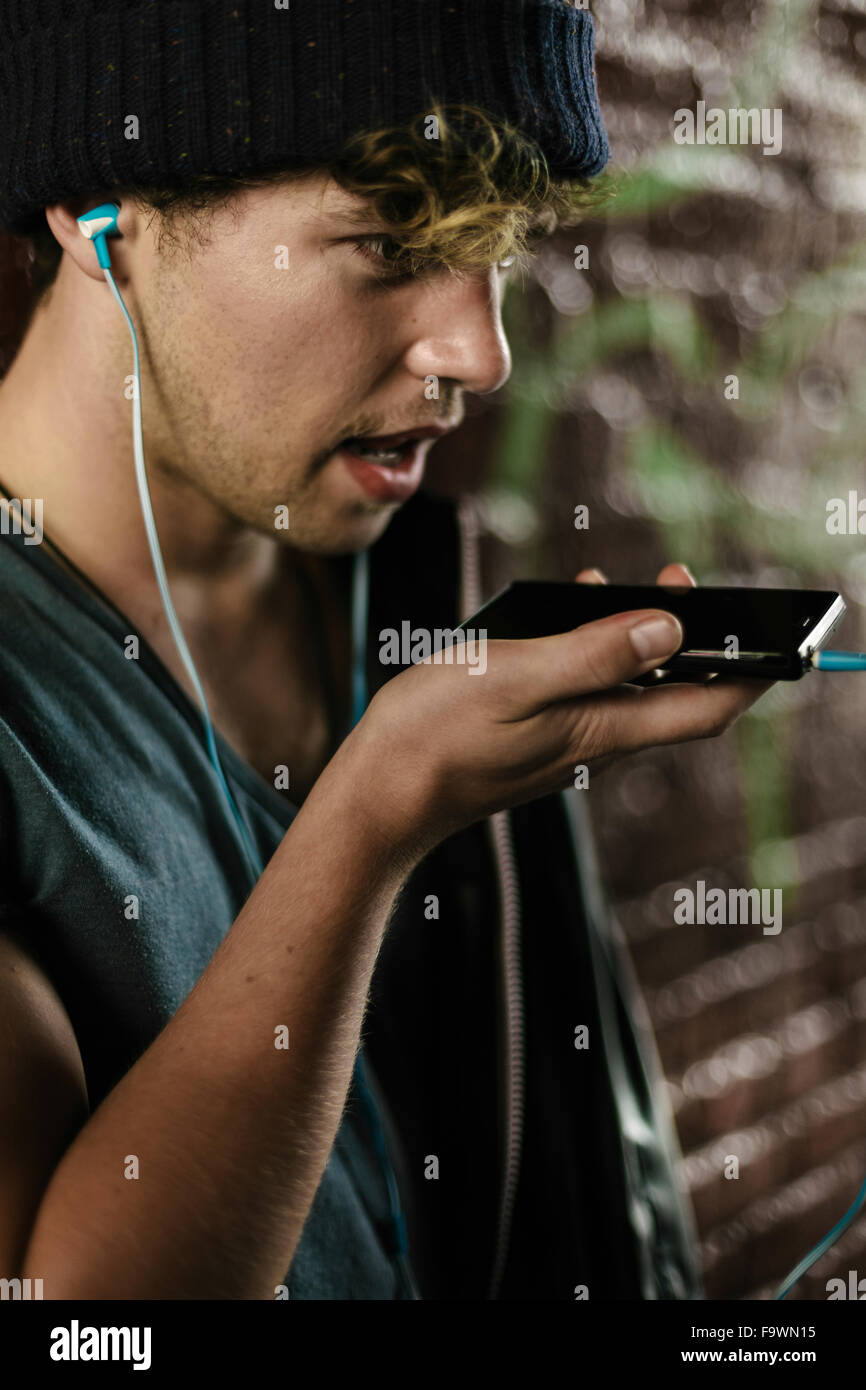 Young man using with smartphone with earphones Stock Photo - Alamy