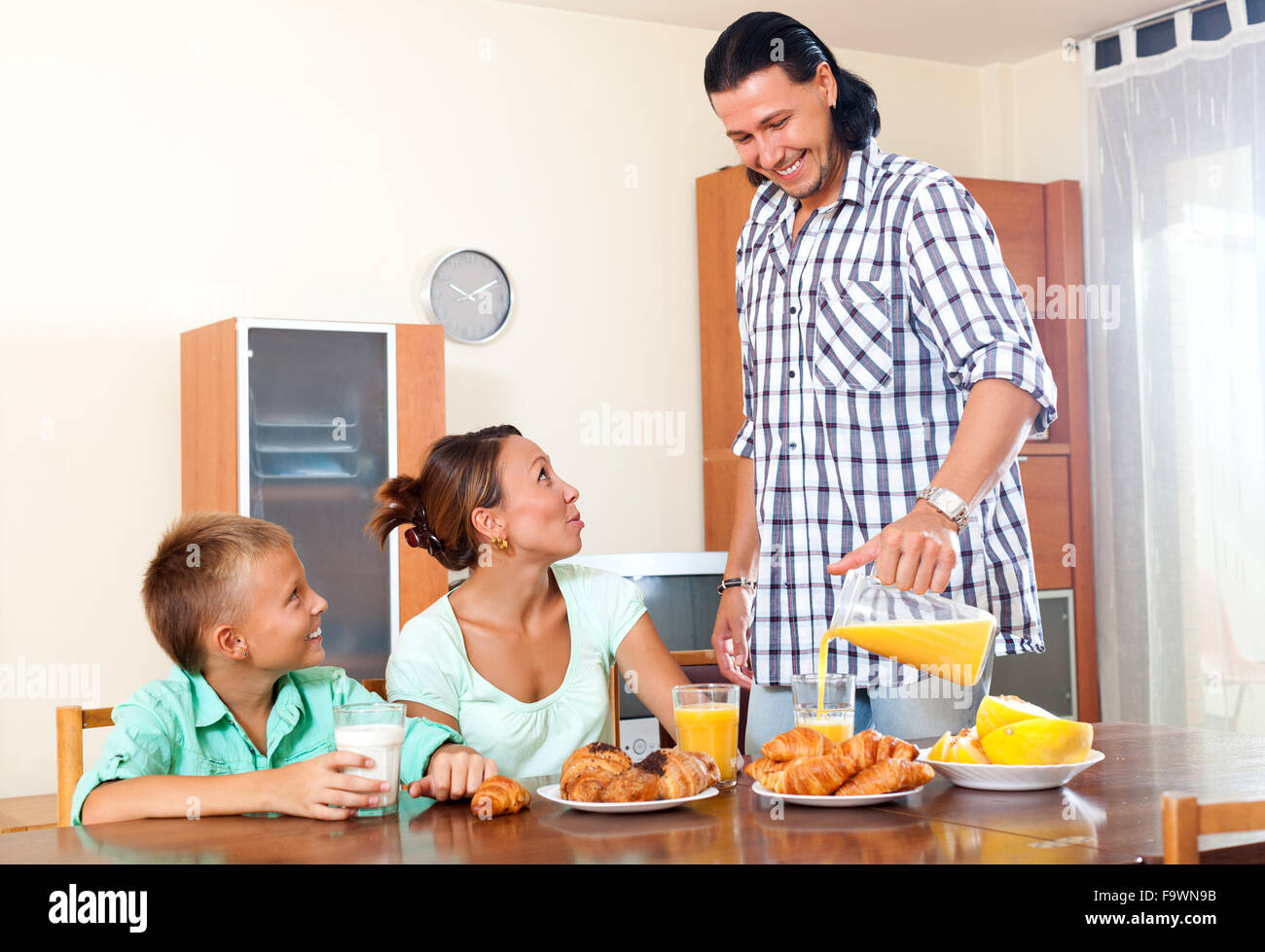 Happy family talking over breakfast at home in morning Stock Photo - Alamy