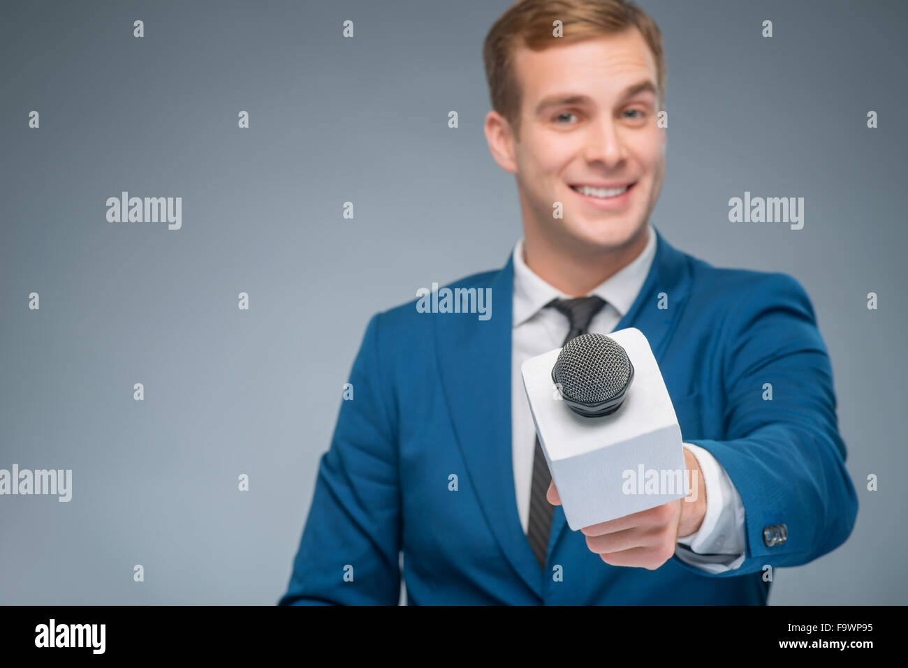 Smiling newsman taking an interview Stock Photo - Alamy