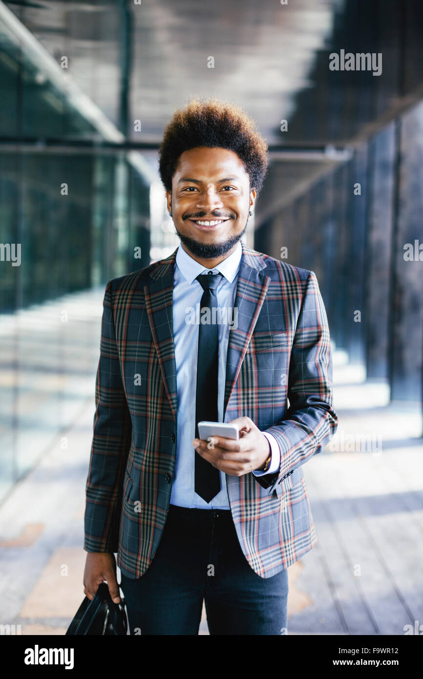 Portrait of confident young businessman with cell phone outdoors Stock Photo - Alamy