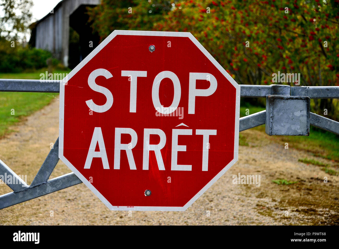 A bilingual stop sign and gate blocking vehicle access Stock Photo - Alamy