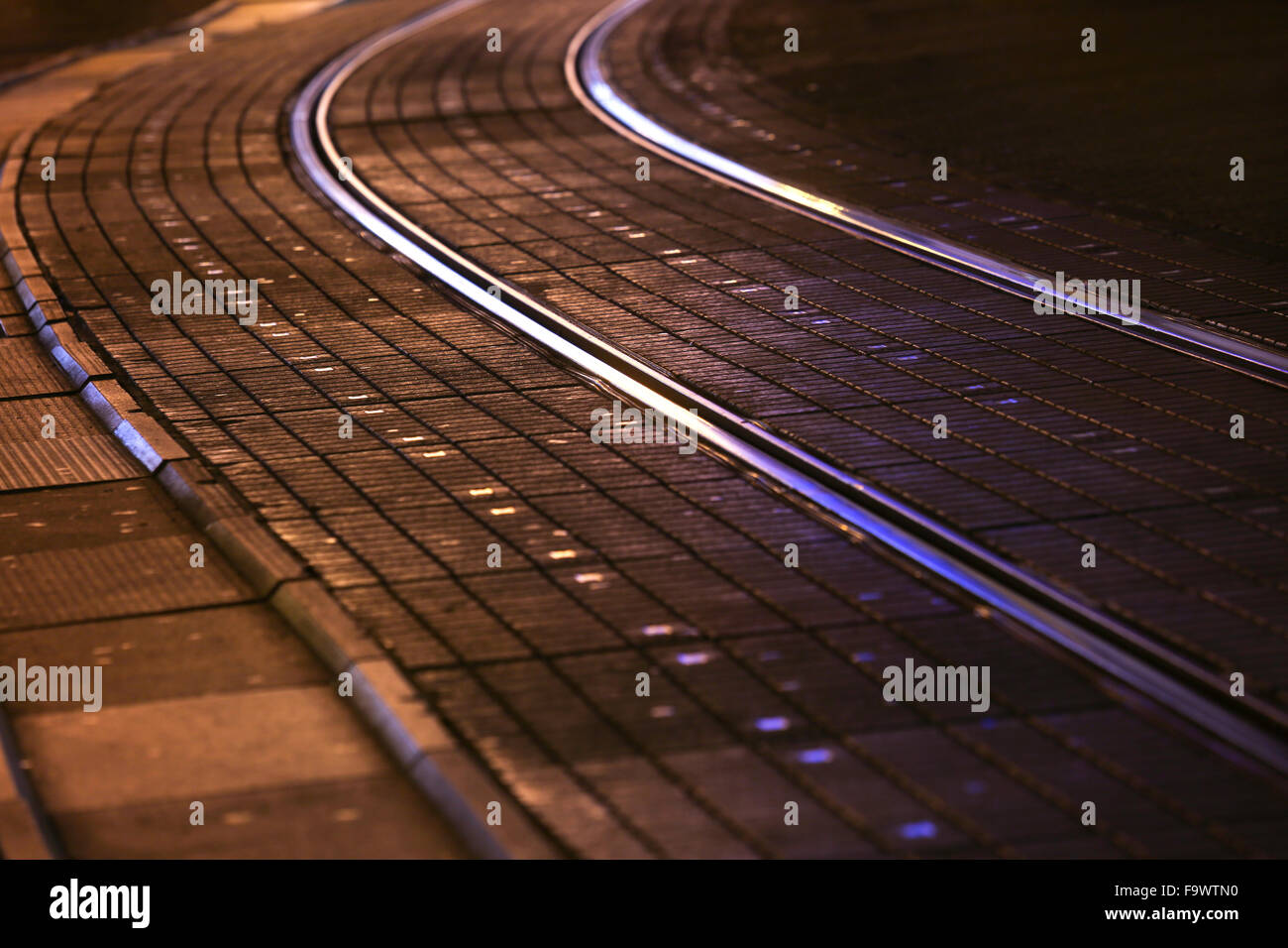 A view of tram rails in city at night Stock Photo - Alamy