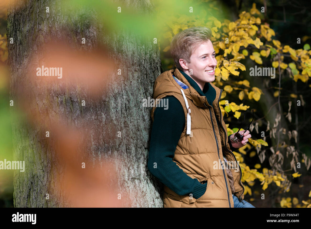 Young man leaning tree trunk park hi-res stock photography and images ...
