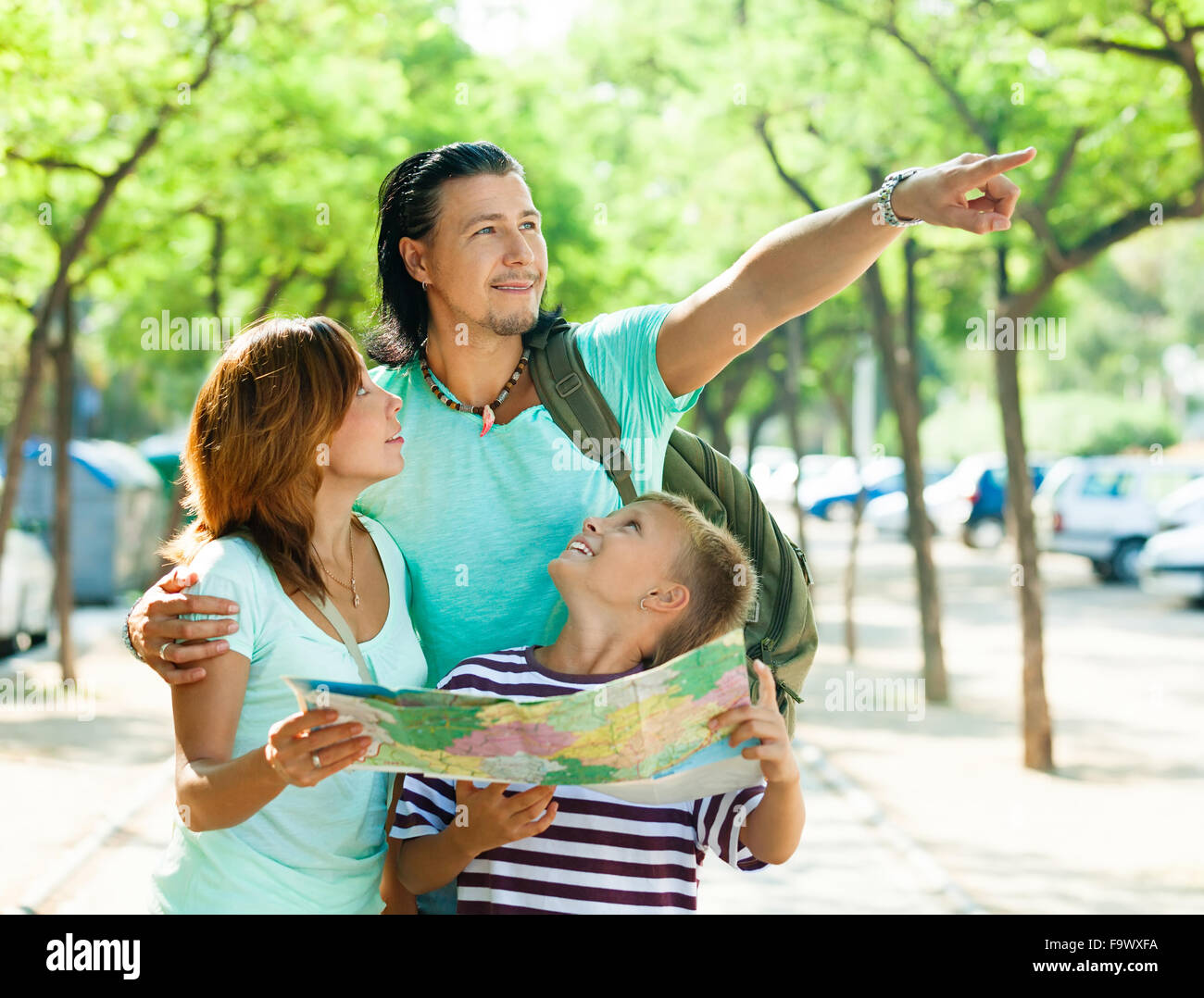 Middle-aged man pointing the direction for wife and son at city Stock ...