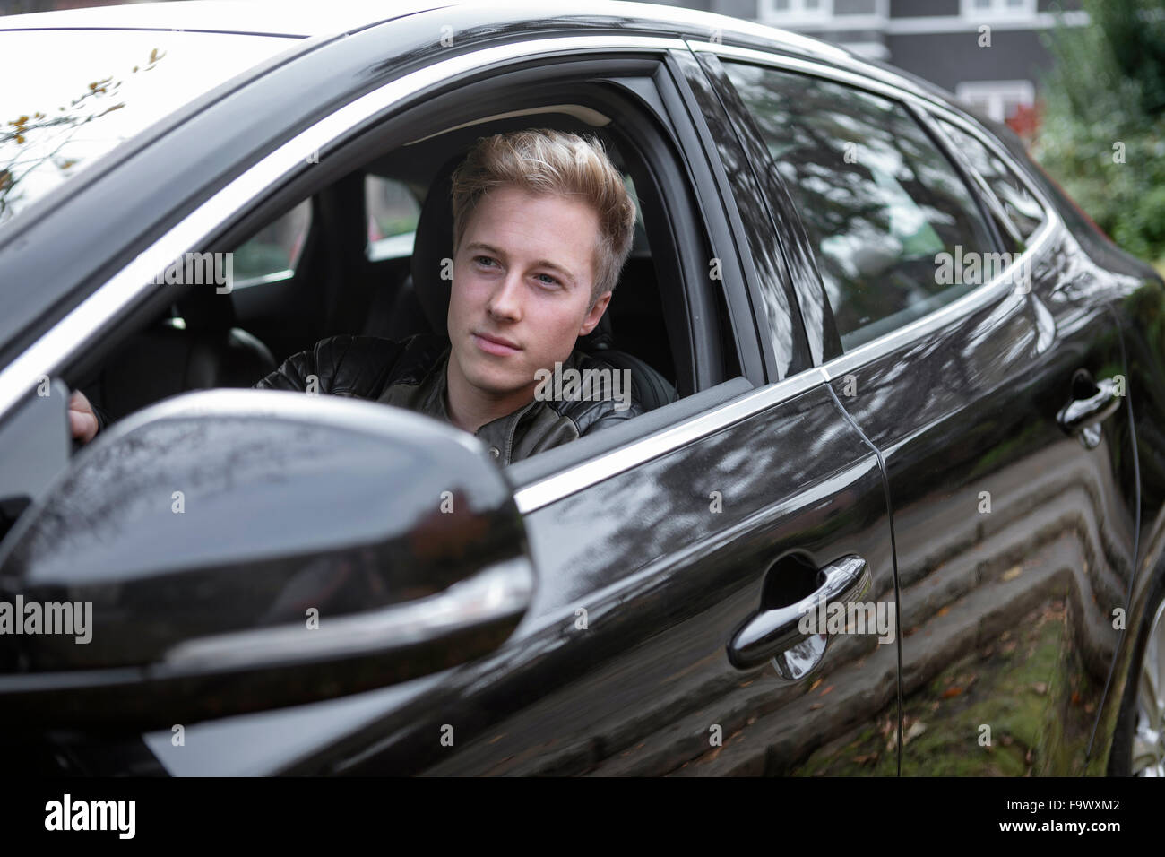 Young man in car looking out of window Stock Photo - Alamy
