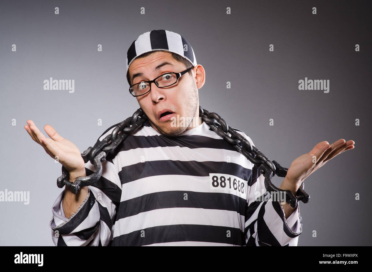 Young prisoner in chains against gray Stock Photo - Alamy