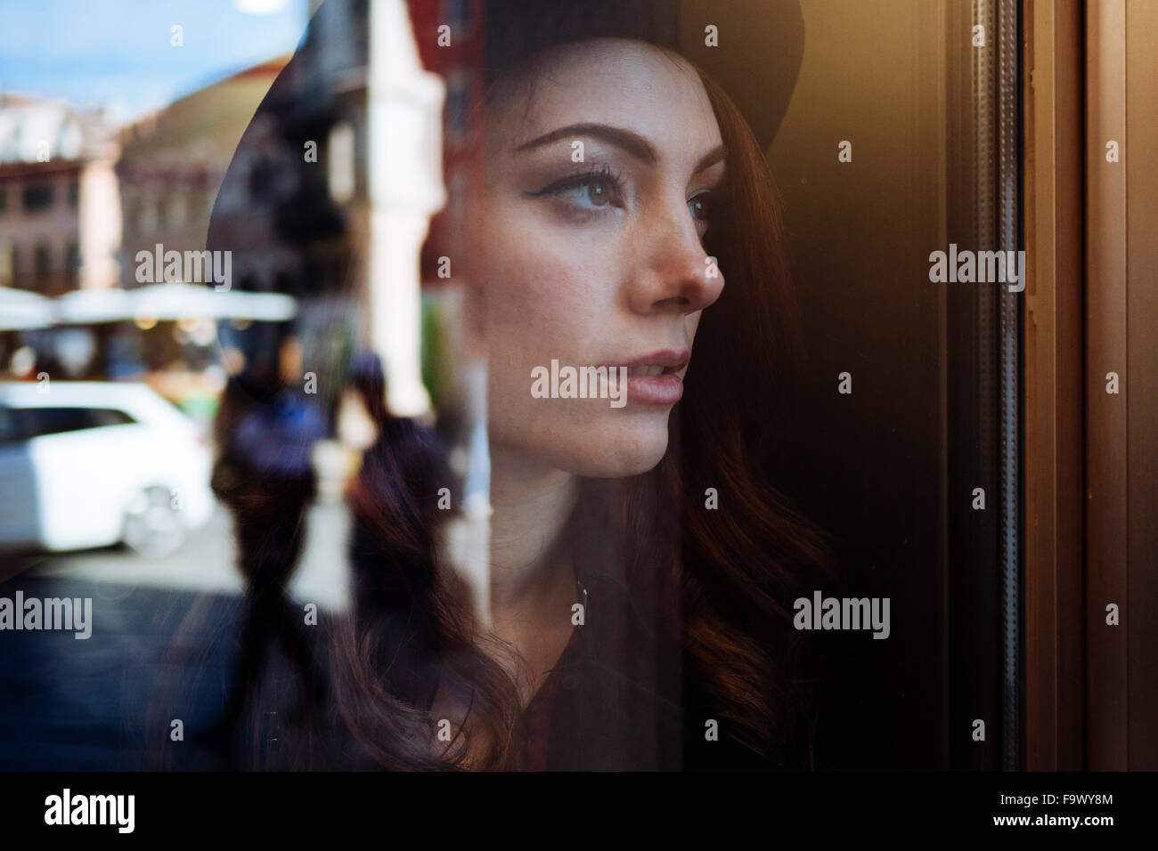 Pensive young woman window looking out of window Stock Photo - Alamy