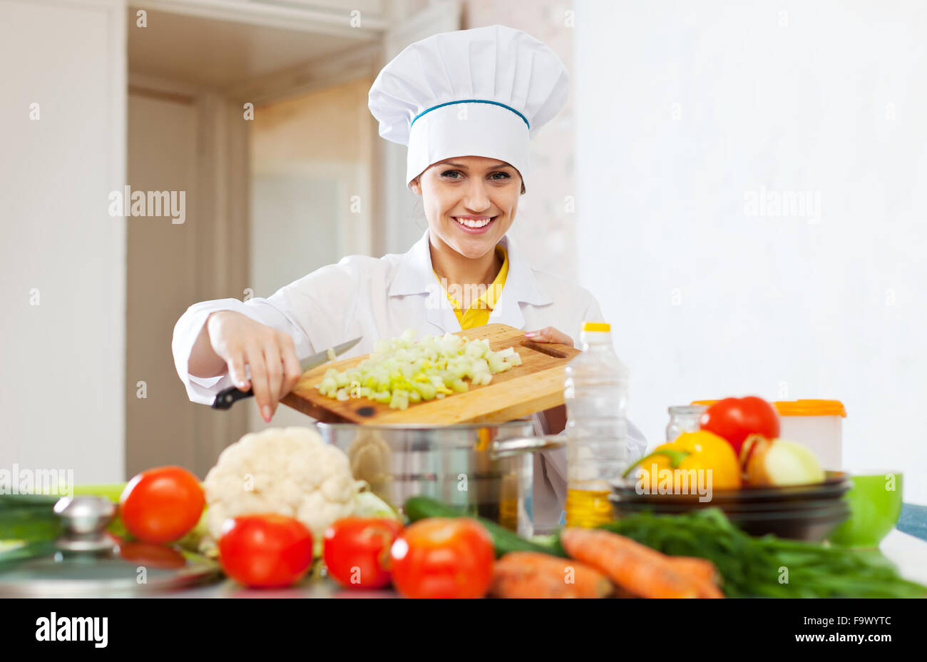 Happy beautiful cook works with vegetables at commercial kitchen Stock ...