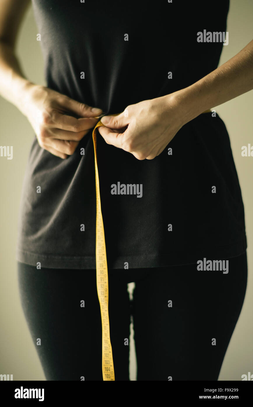 Mid-adult woman measuring waist Stock Photo - Alamy