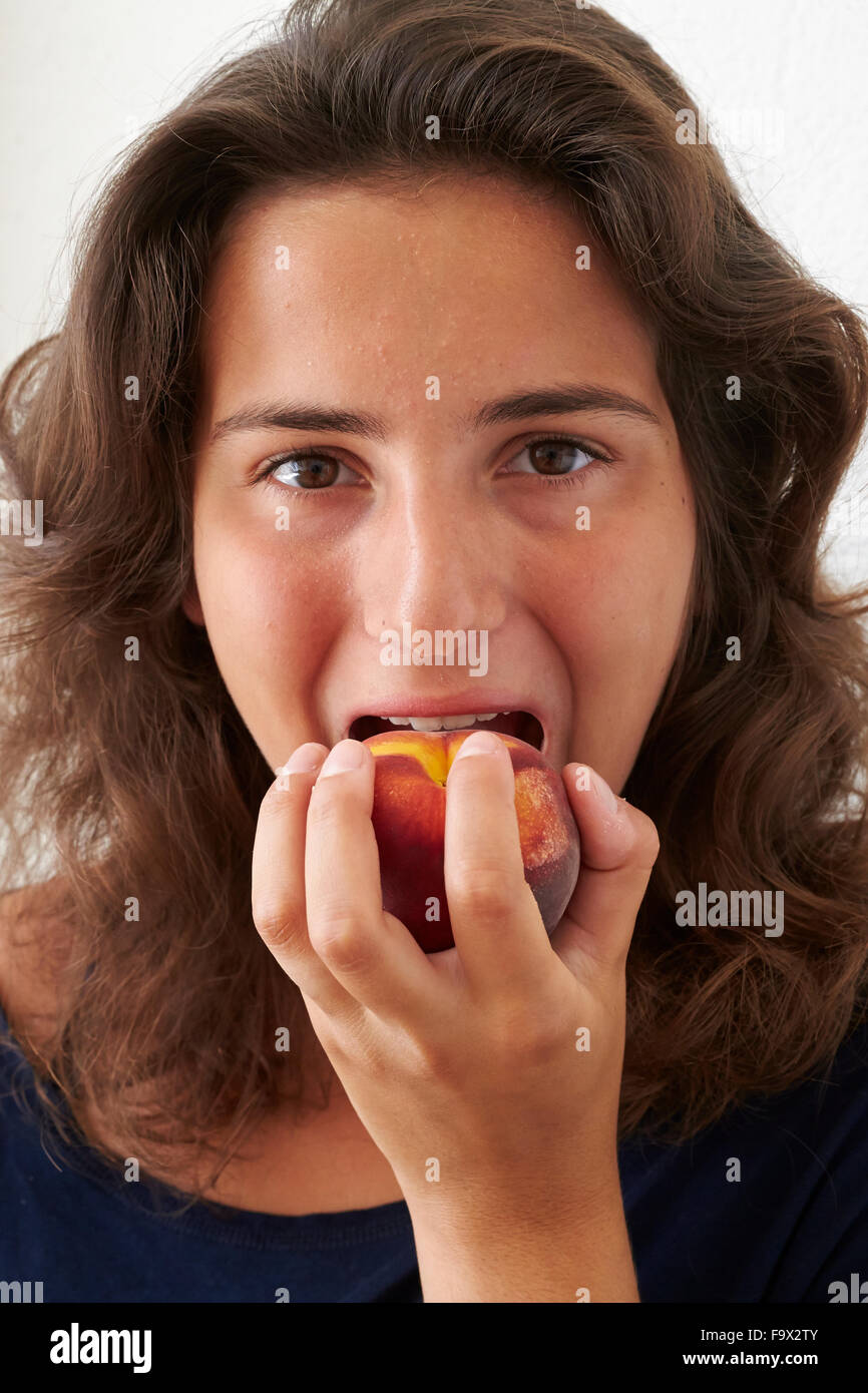 Teenager eating a peach Stock Photo - Alamy