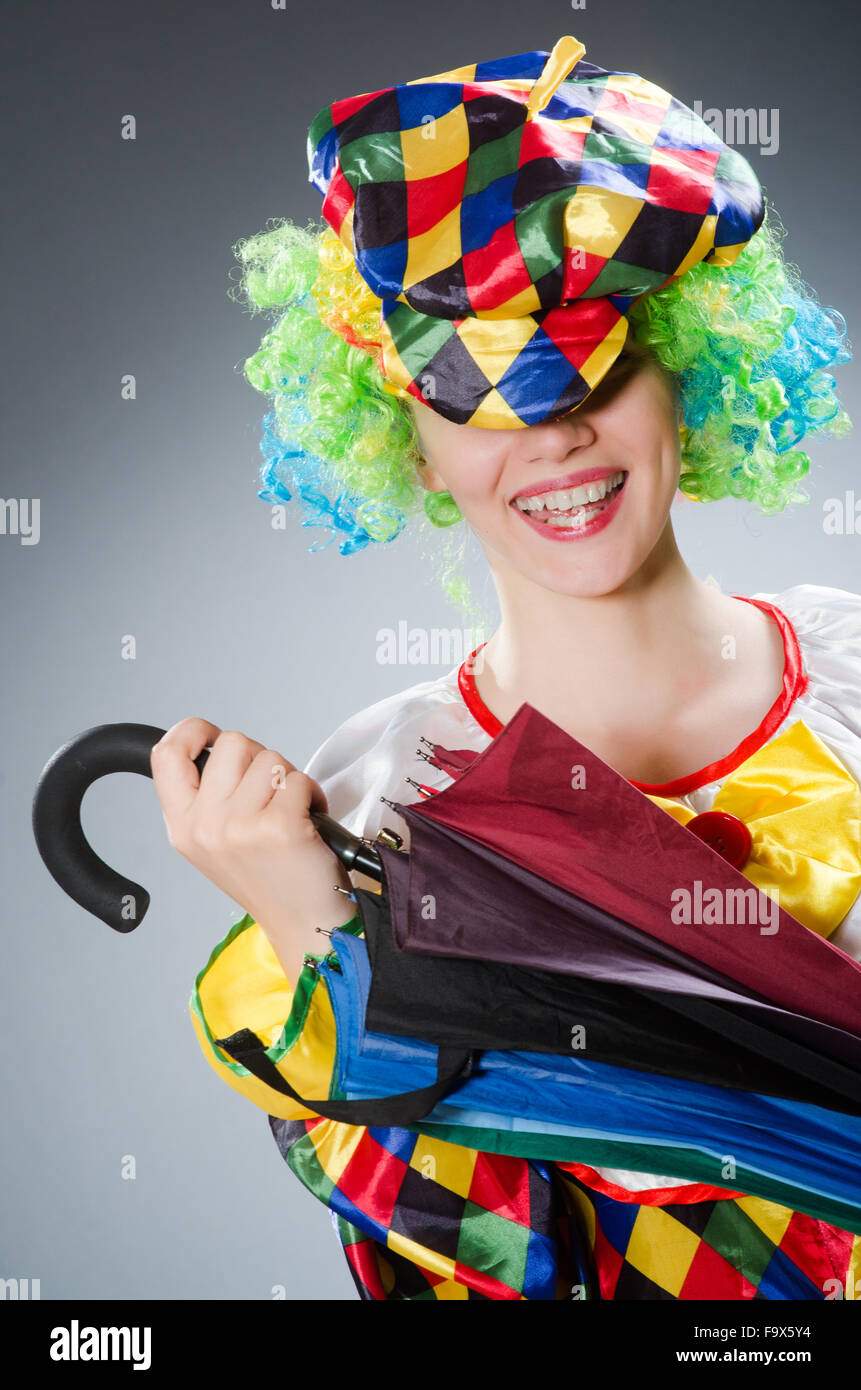 Clown with umbrella in funny concept Stock Photo - Alamy