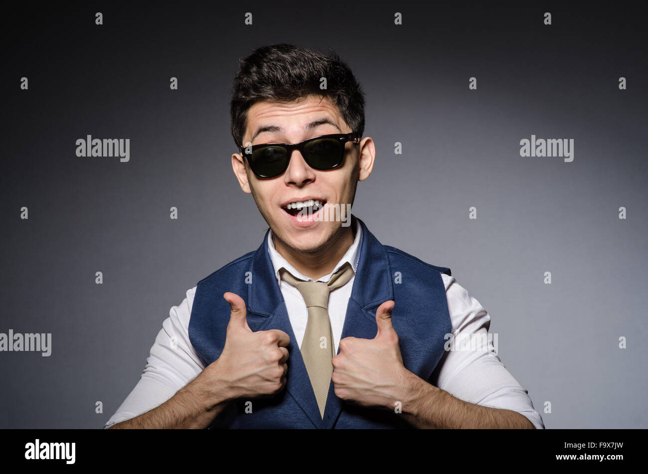 Young man in blue vest against gray Stock Photo - Alamy