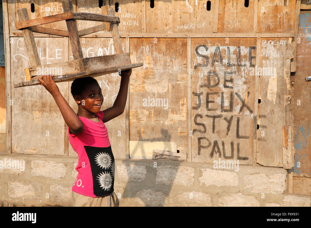 Young girl carrying a table on her head Stock Photo - Alamy
