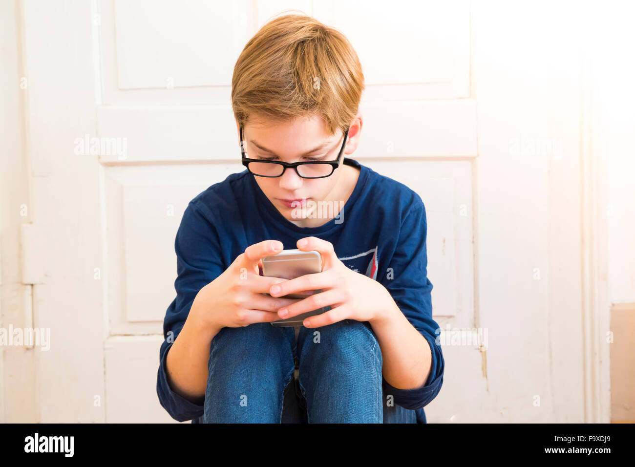 Boy looking at his smartphone Stock Photo - Alamy