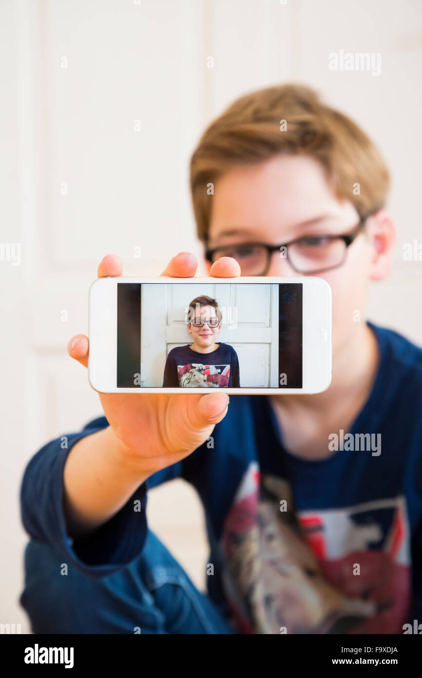 Boy showing with his portrait on the display Stock Photo - Alamy