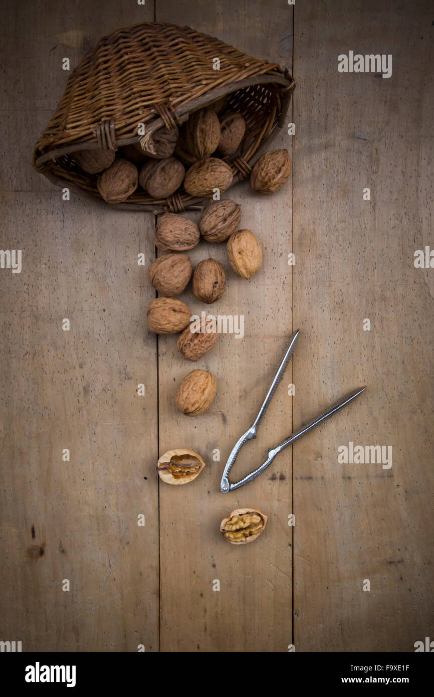 Wickerbasket, walnuts and nutcracker on wood Stock Photo - Alamy