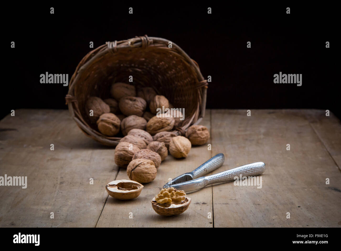 Wickerbasket, walnuts and nutcracker on wood Stock Photo - Alamy