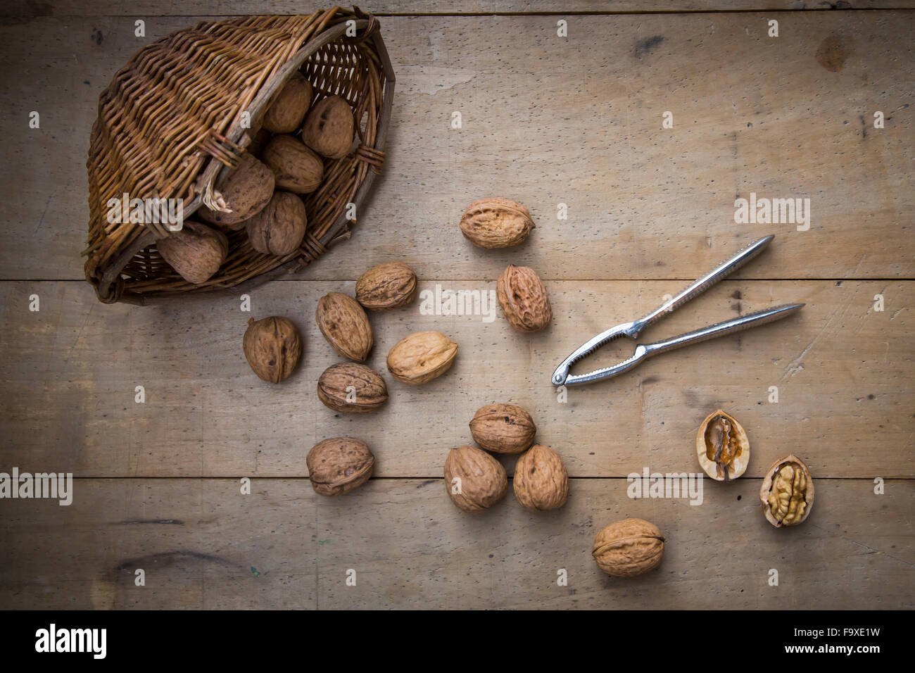 Wickerbasket, walnuts and nutcracker on wood Stock Photo - Alamy