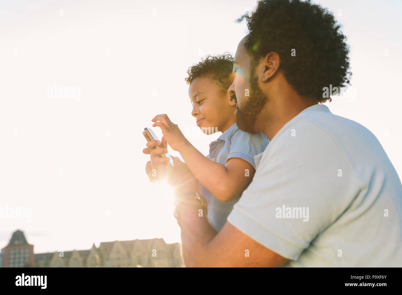 Father with son exploring cell phone Stock Photo - Alamy