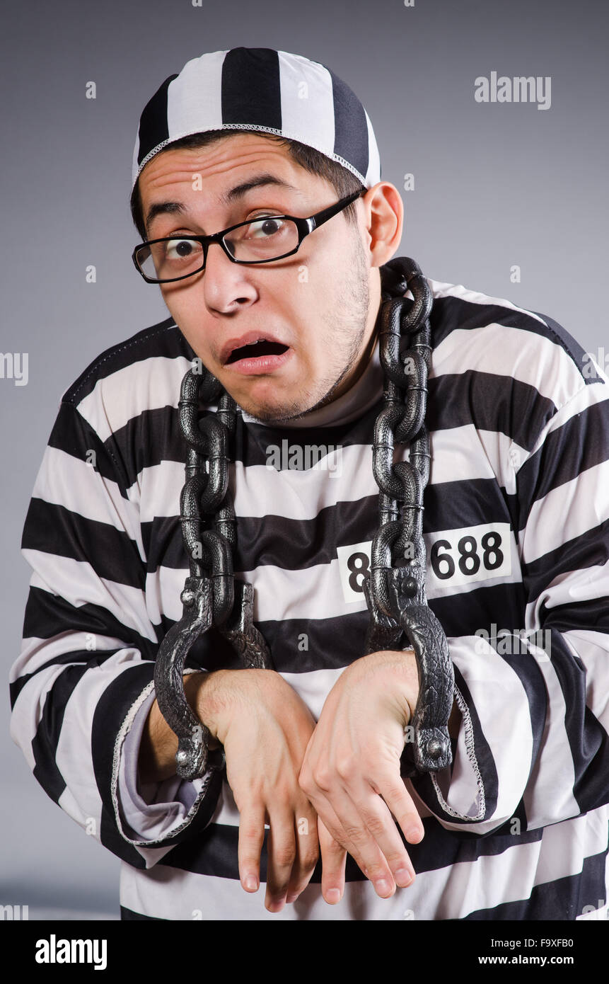 Young prisoner in chains against gray Stock Photo - Alamy