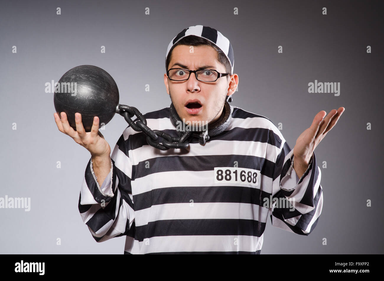 Young prisoner in chains against gray Stock Photo - Alamy