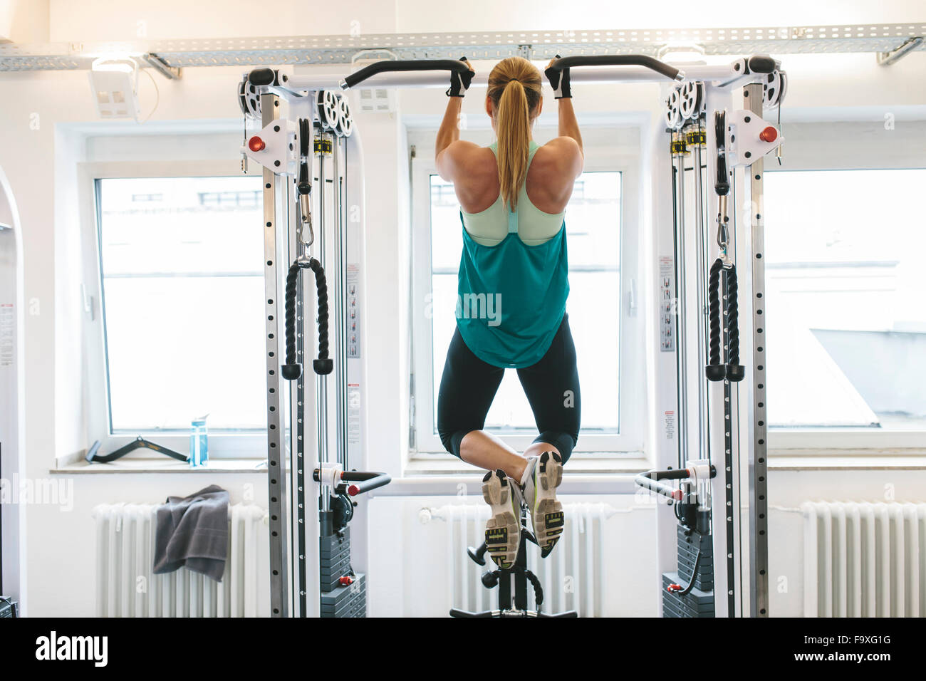 Woman doing pull-ups in gym Stock Photo - Alamy