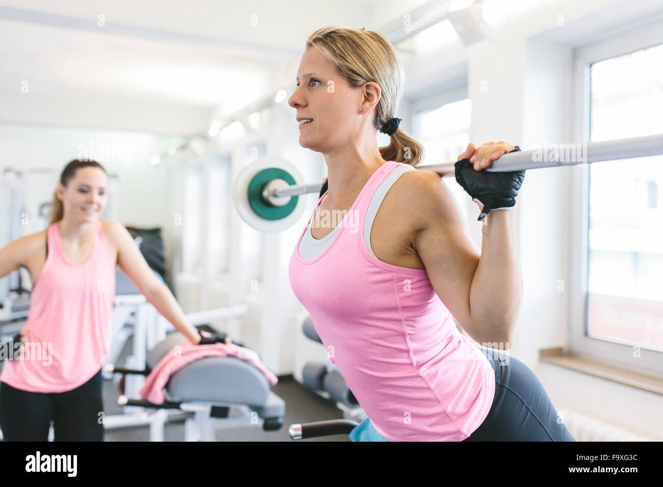 Woman doing weighted back extensions in gym Stock Photo - Alamy