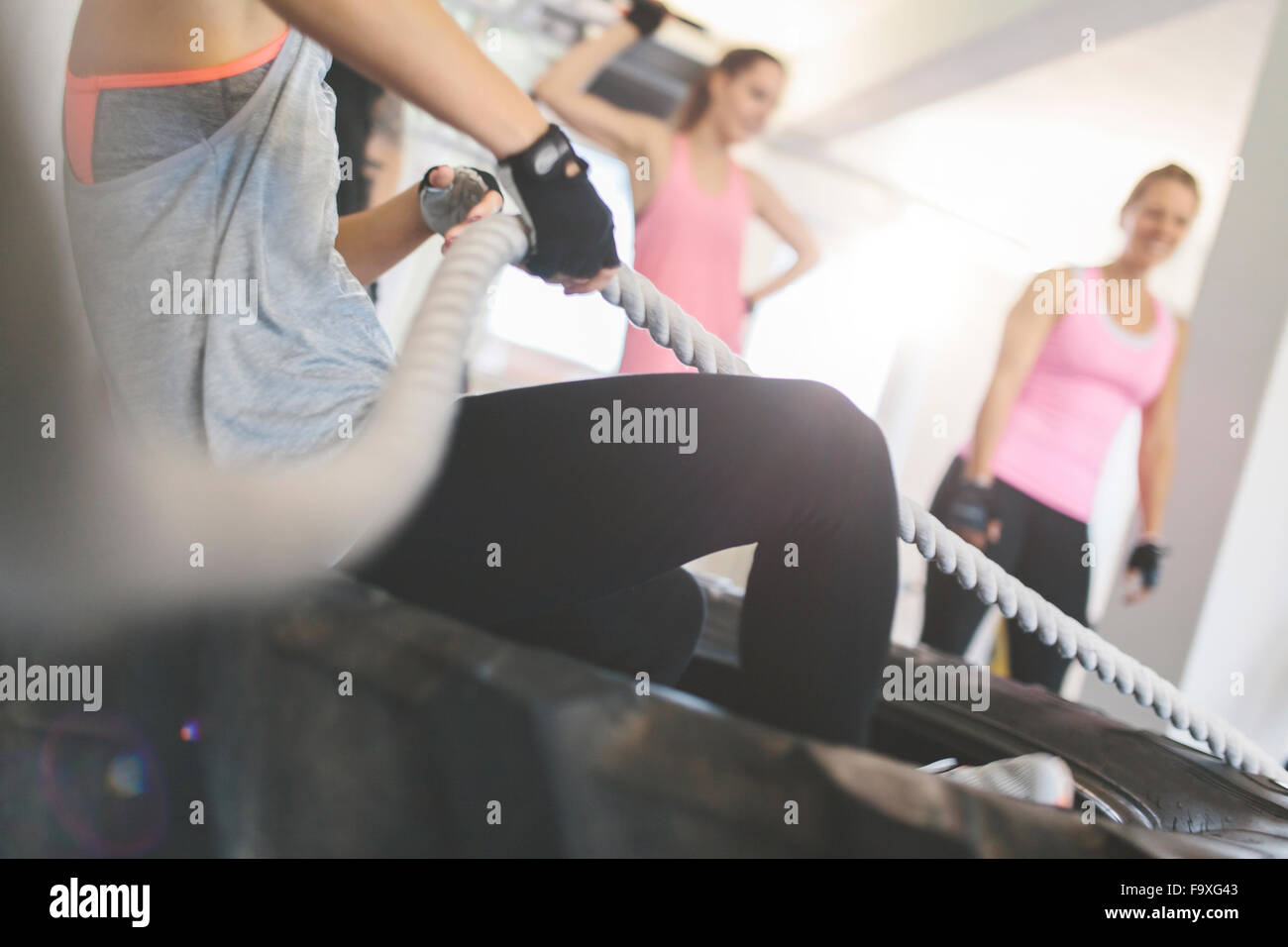 Woman pulling a sled with a rope in gym Stock Photo - Alamy