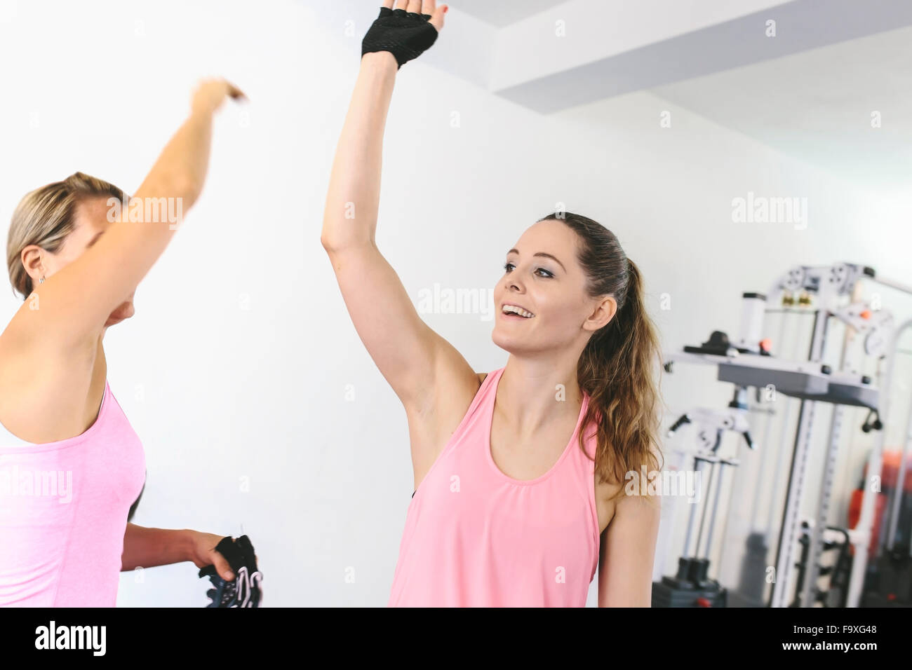 Two women high fiving after workout in gym Stock Photo - Alamy