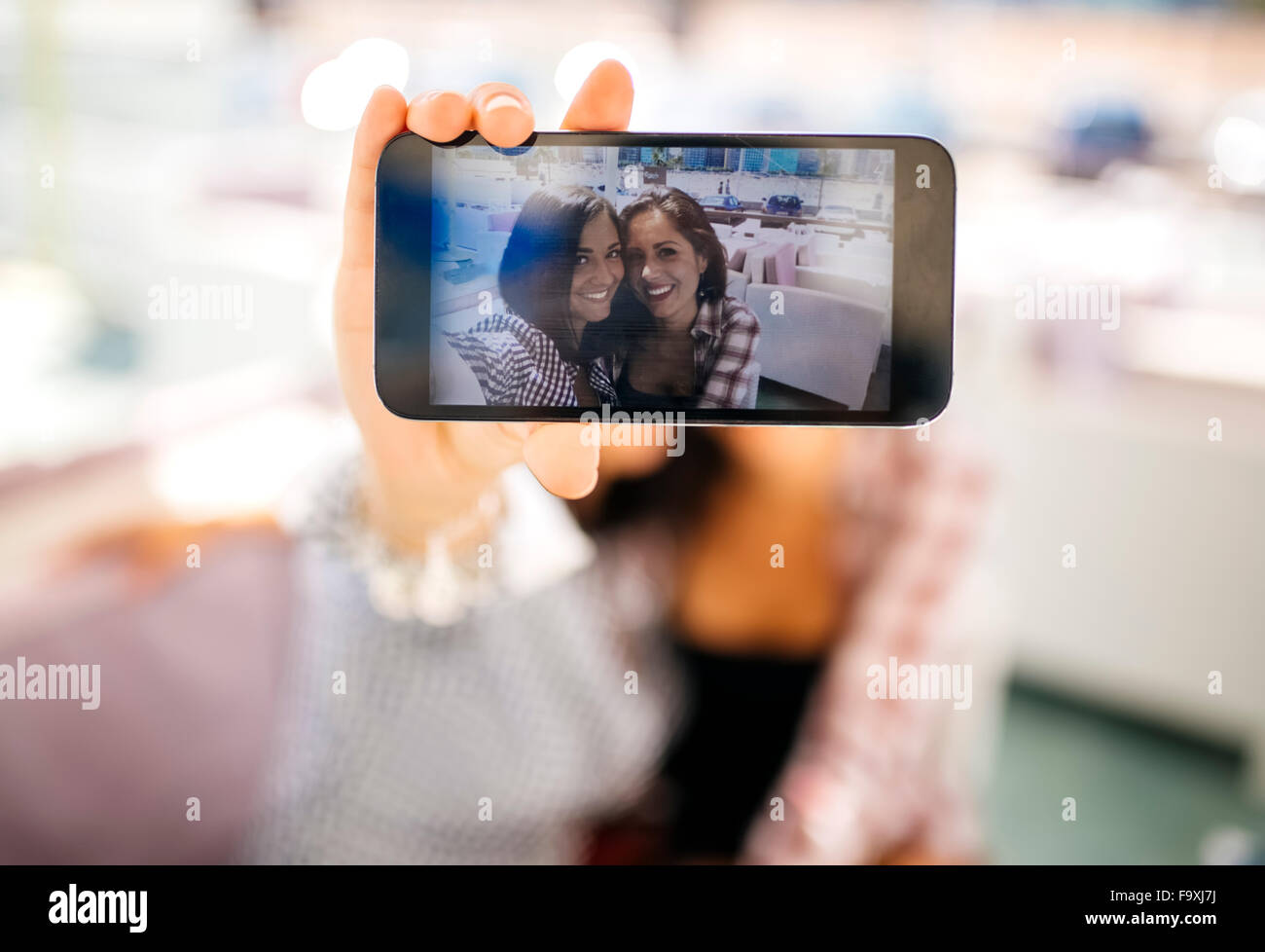 Selfie of two smiling female friends on cell phone display Stock Photo ...