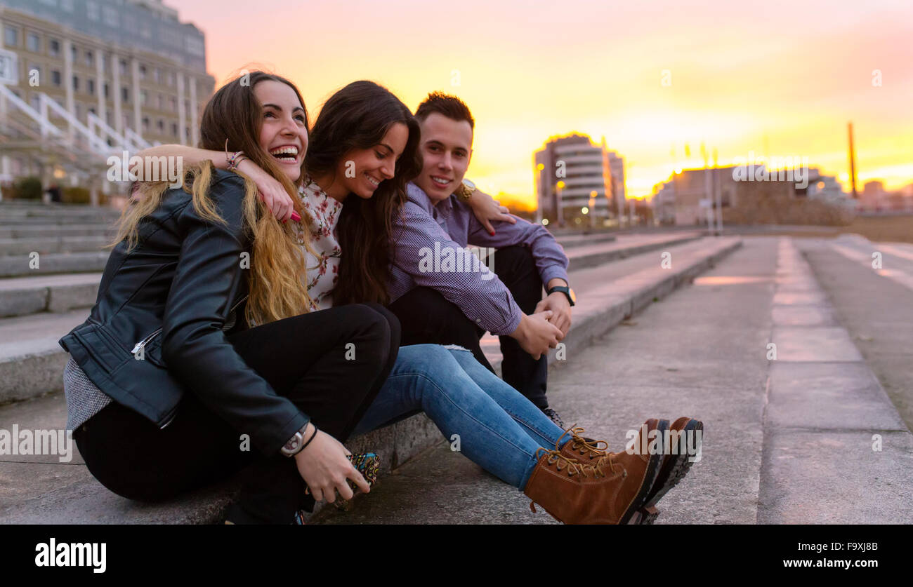 Three friends having fun together at sunset Stock Photo - Alamy
