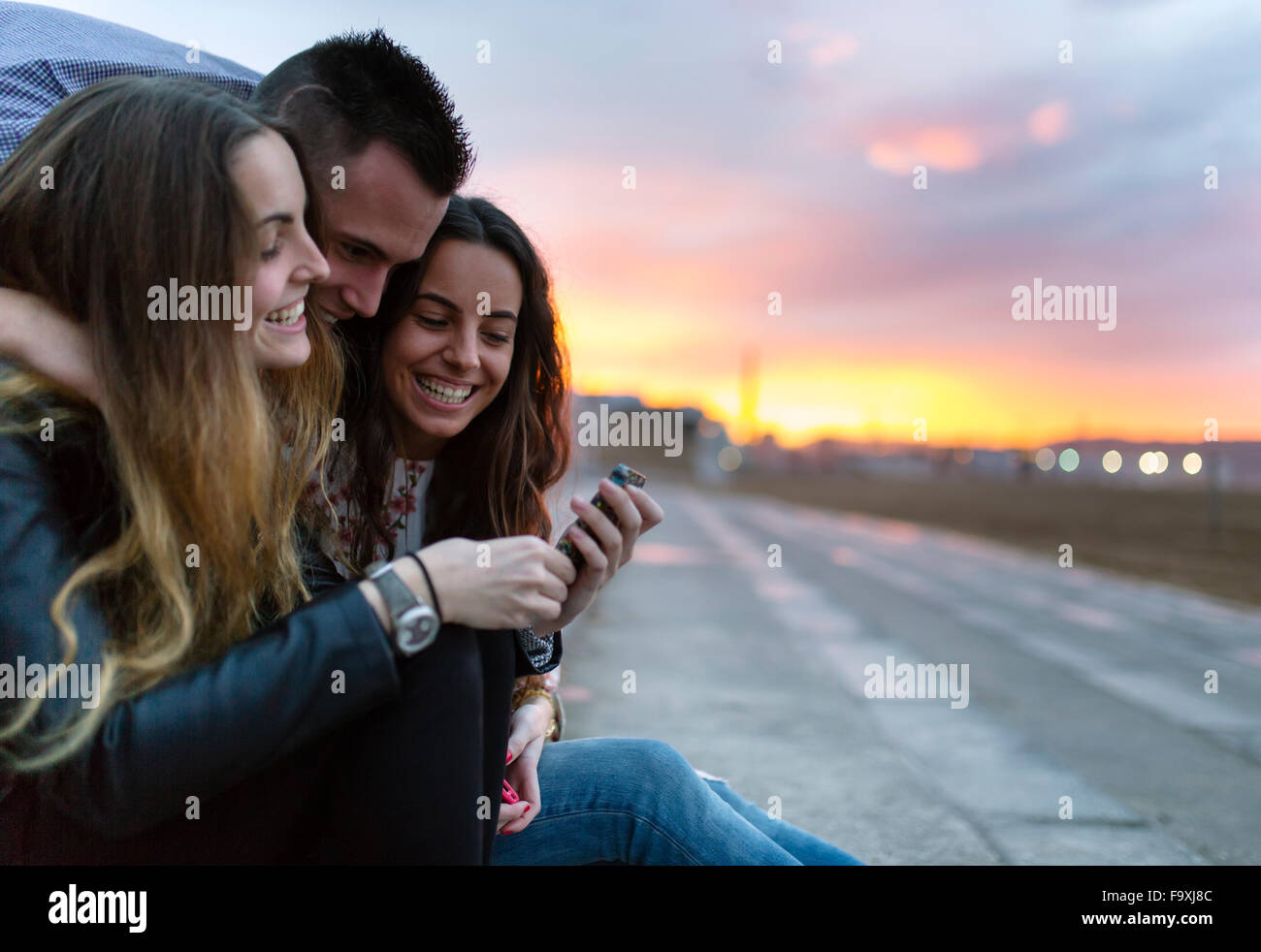 Three happy friends at evening twilight Stock Photo - Alamy