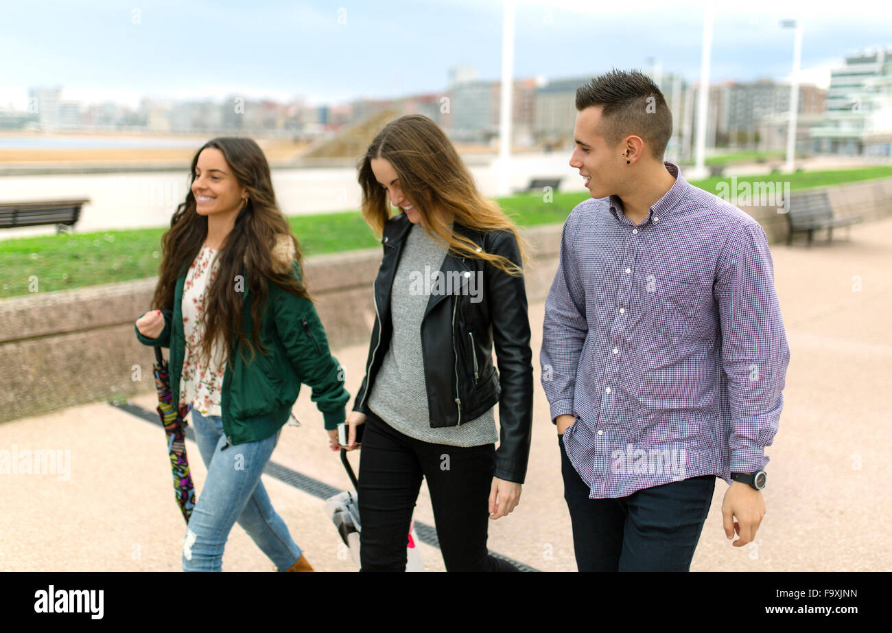 Three happy friends walking down the street Stock Photo - Alamy