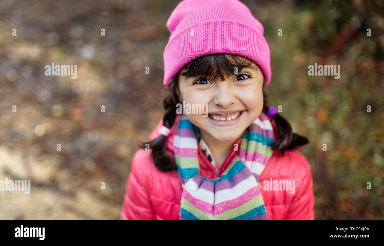 Portrait of grinning little girl wearing cap and scarf in autumn Stock ...