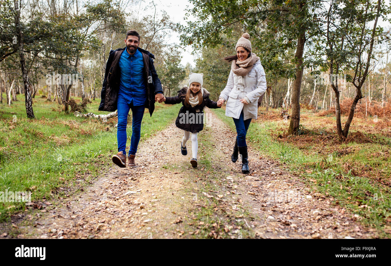 Happy parents with daughter walking on forest path Stock Photo - Alamy
