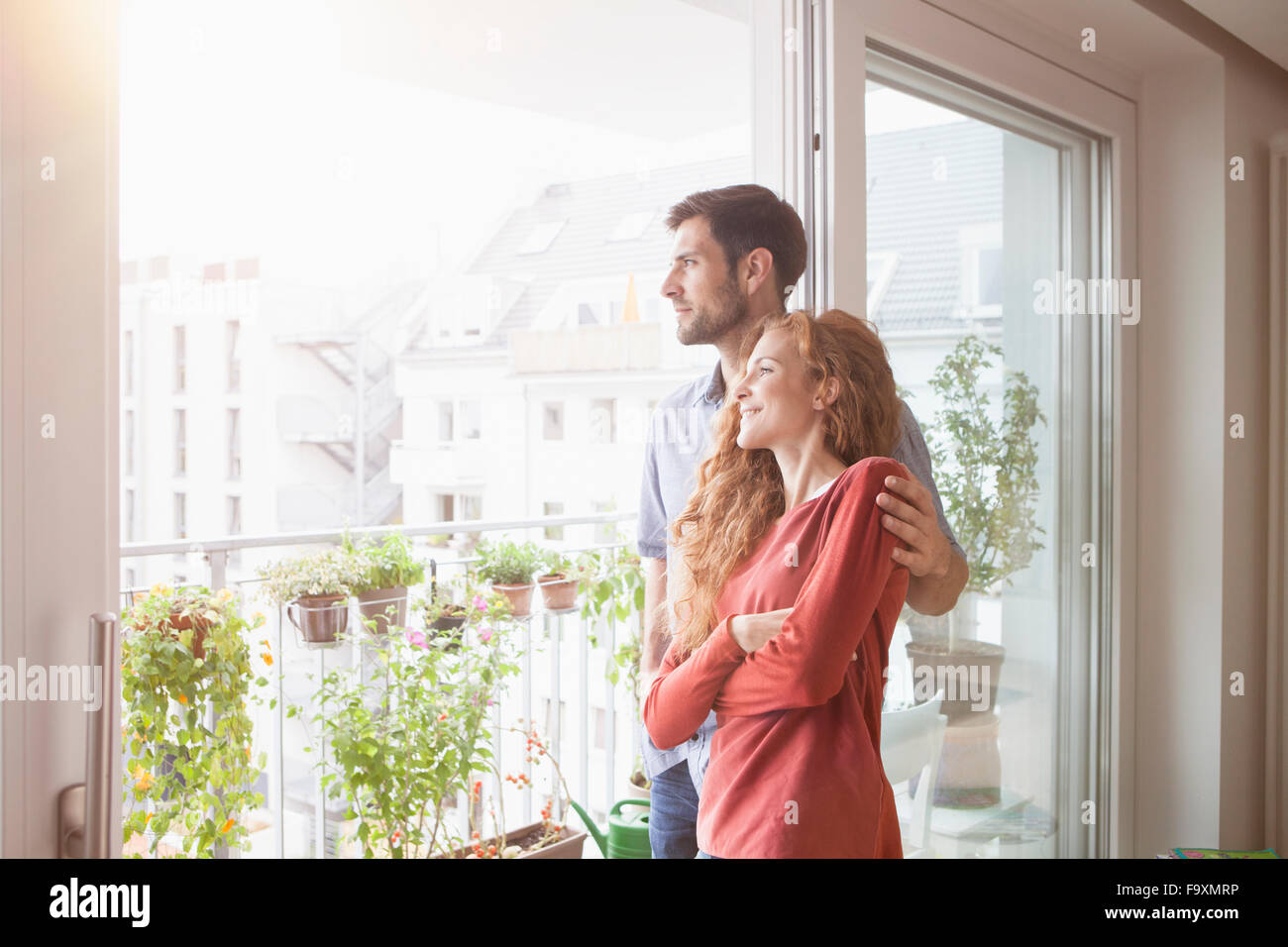 Couple looking out of window Stock Photo - Alamy