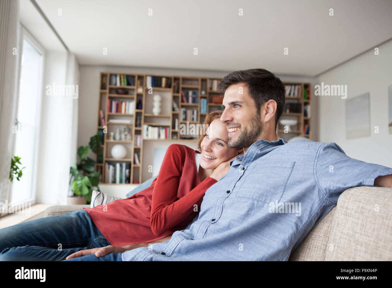 Relaxed couple at home on couch Stock Photo - Alamy