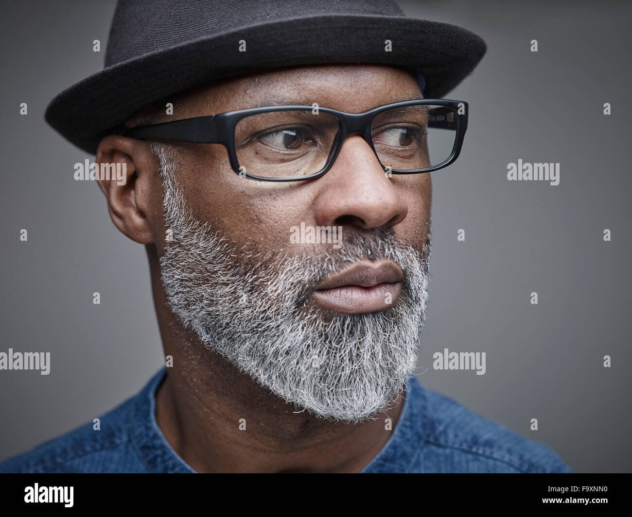 Portrait of man with grey beard wearing spectacles and hat Stock Photo ...
