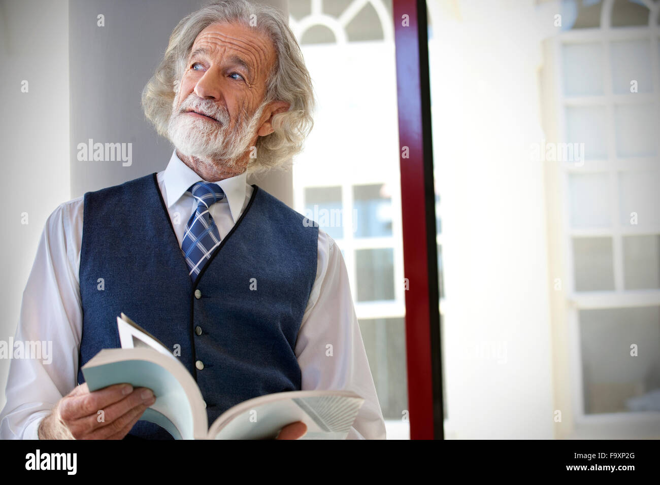 Senior professor holding book Stock Photo - Alamy