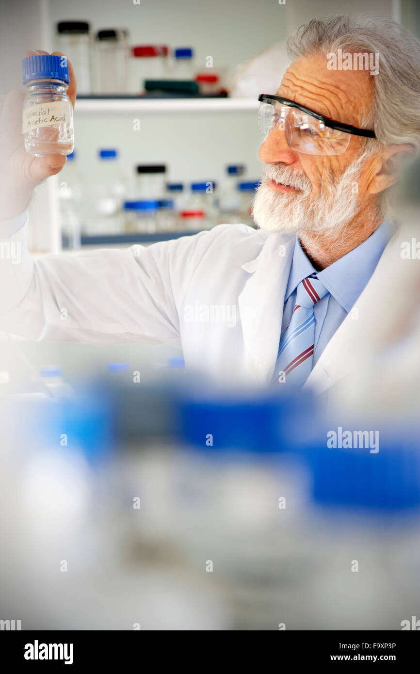 Senior professor looking at laboratory glass Stock Photo - Alamy