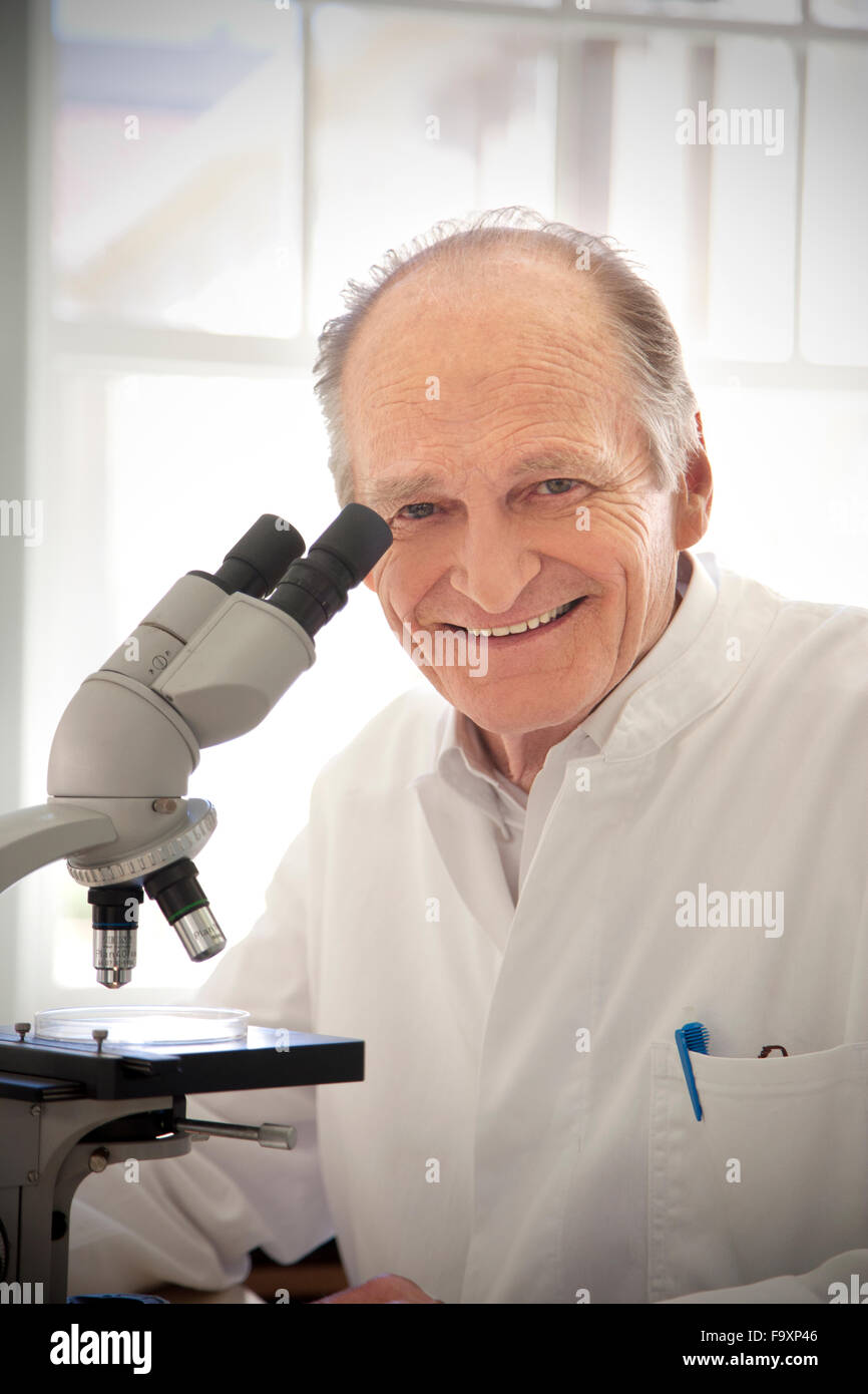 Professor in laboratory examining samples under microscope Stock Photo ...
