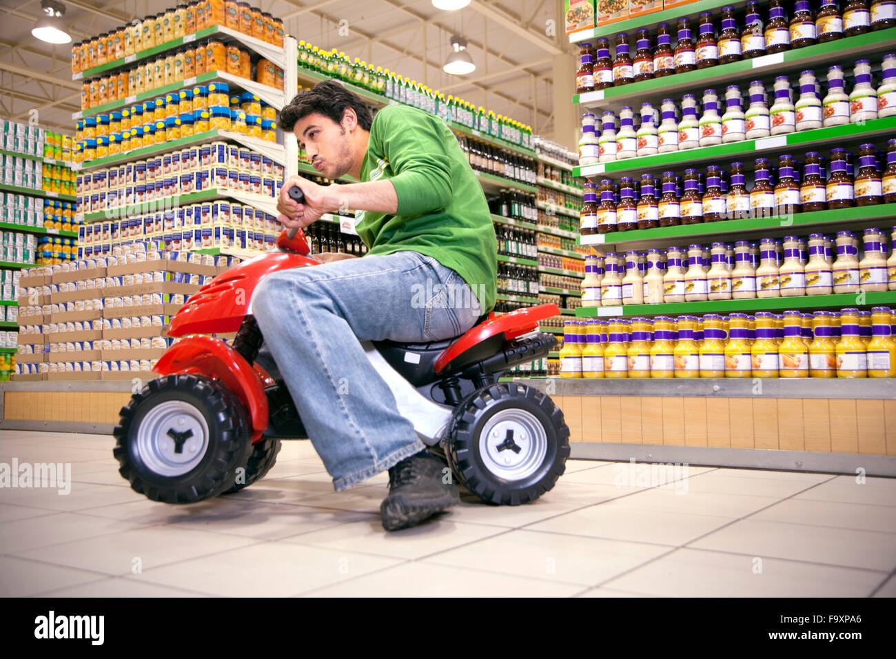 Man driving with toy car in a supermarket Stock Photo - Alamy