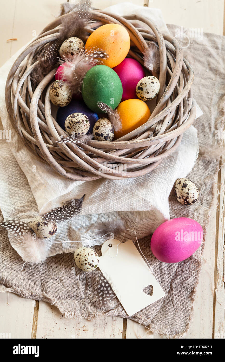 Colourful Easter eggs and quail eggs in rustic nest Stock Photo - Alamy