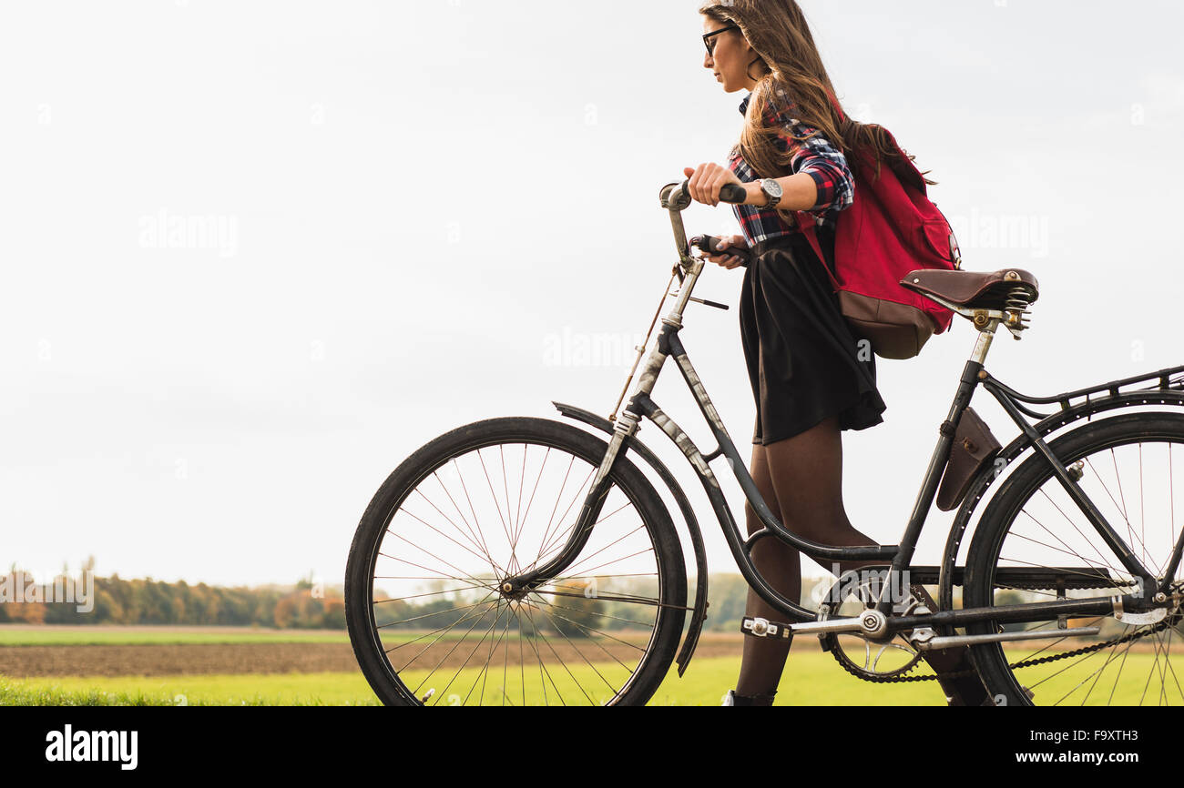 Young woman pushing her bicycle in rural landscape Stock Photo - Alamy