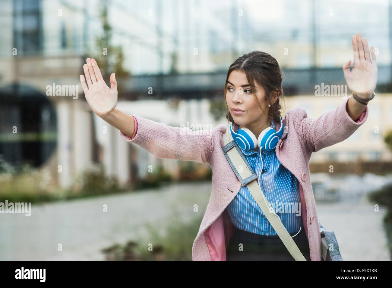 Young woman leaning against glass front Stock Photo - Alamy
