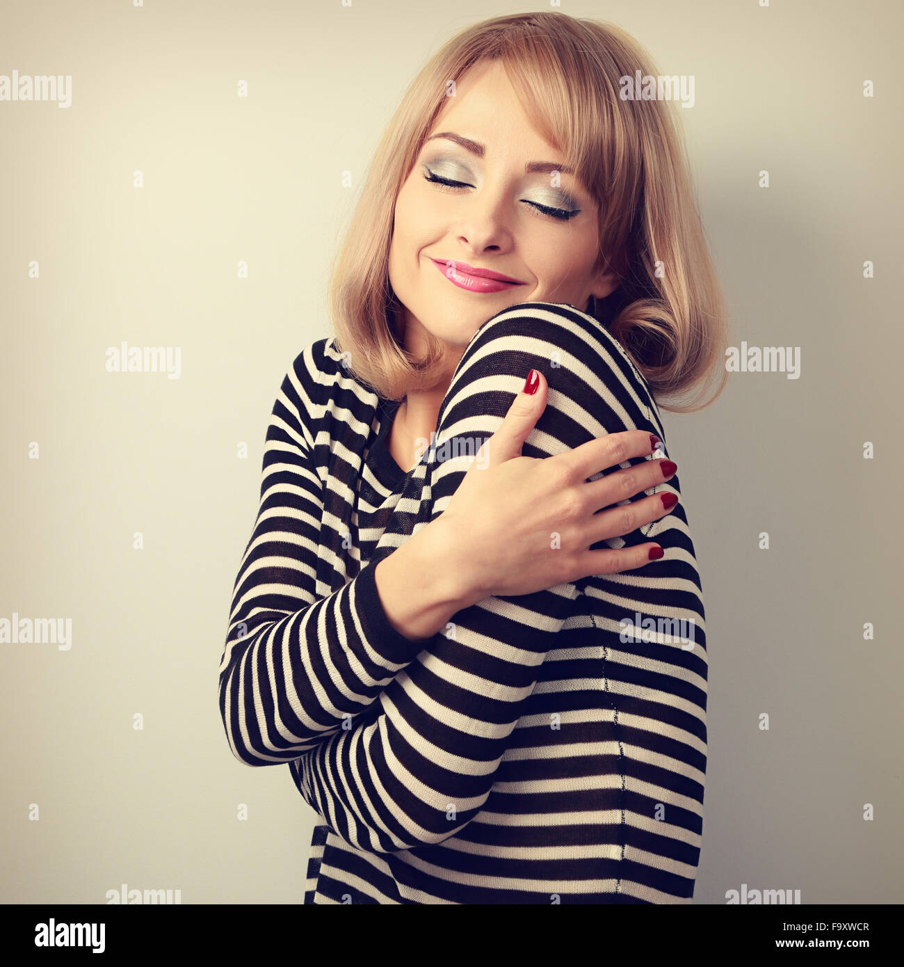 Happy makeup blond woman hugging herself with natural emotion on ...